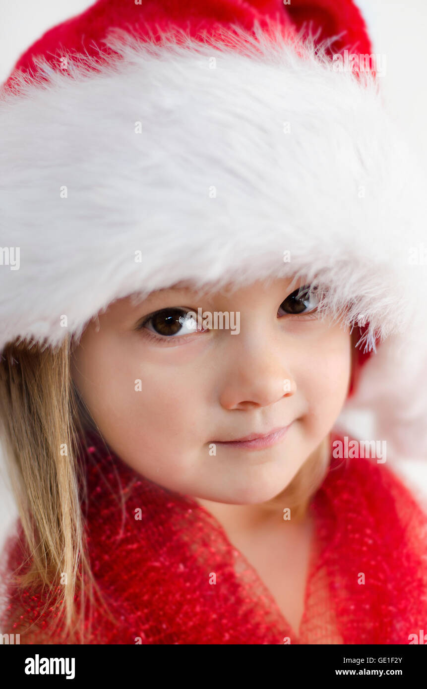 Portrait of a girl wearing a santa hat smiling hi-res stock photography ...