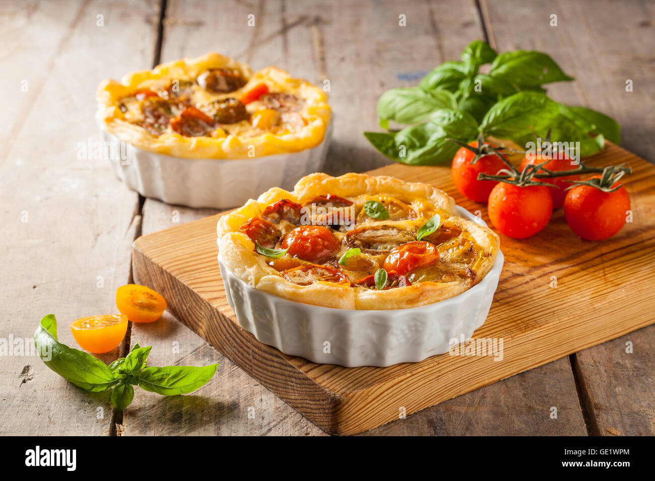 Quiche with cherry tomatoes on a rustic wooden table Stock Photo - Alamy
