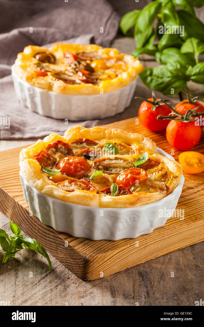 Quiche with cherry tomatoes on a rustic wooden table Stock Photo - Alamy