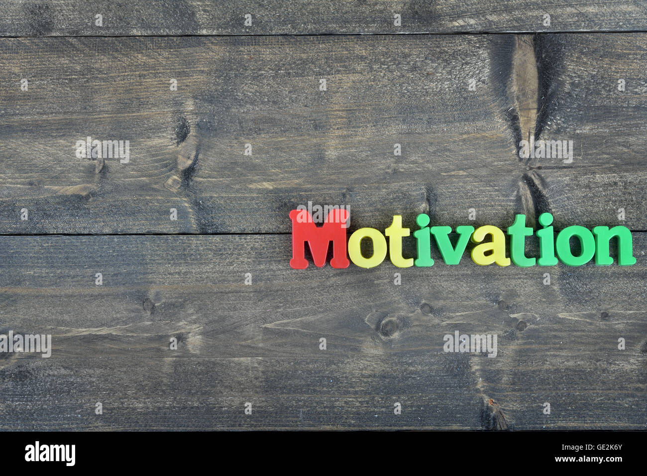 Motivation word on wooden table Stock Photo - Alamy