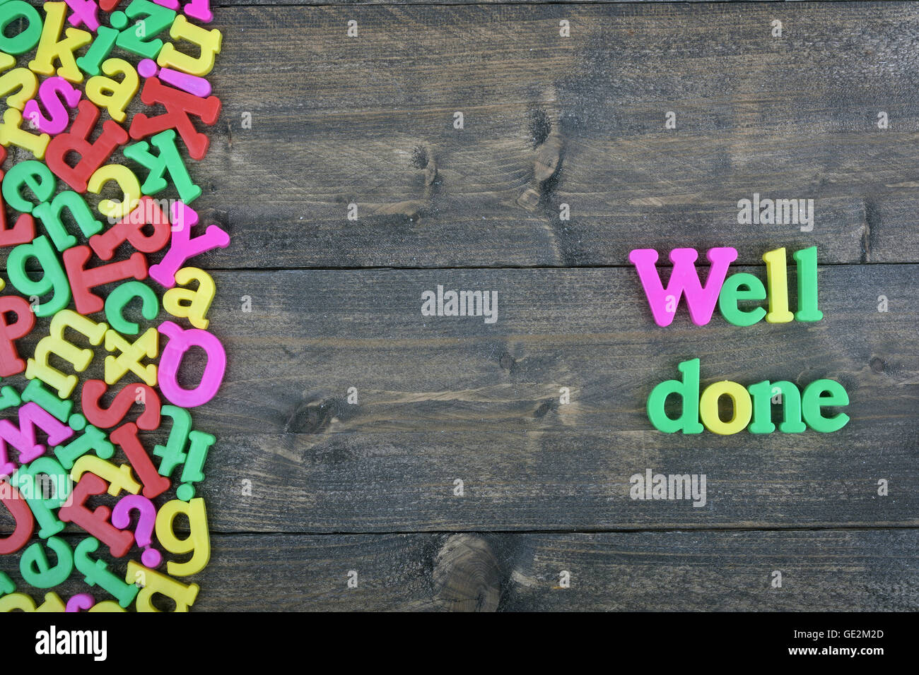 Well done word on wooden table Stock Photo - Alamy
