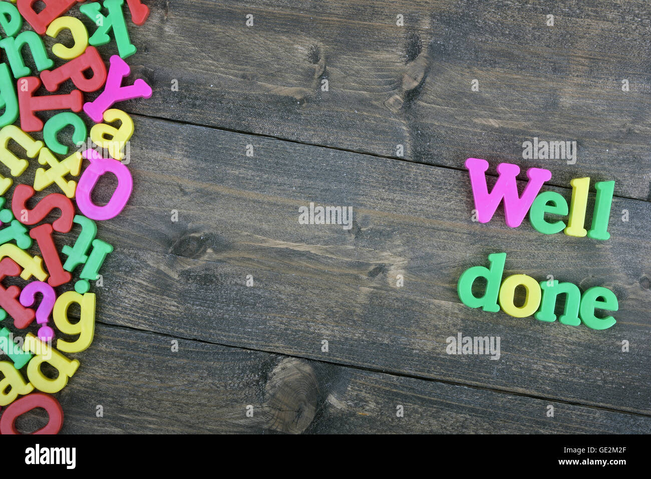 Well done word on wooden table Stock Photo - Alamy