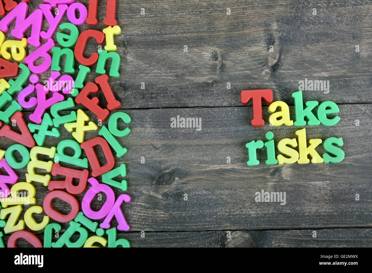 Take risks word on wooden table Stock Photo - Alamy