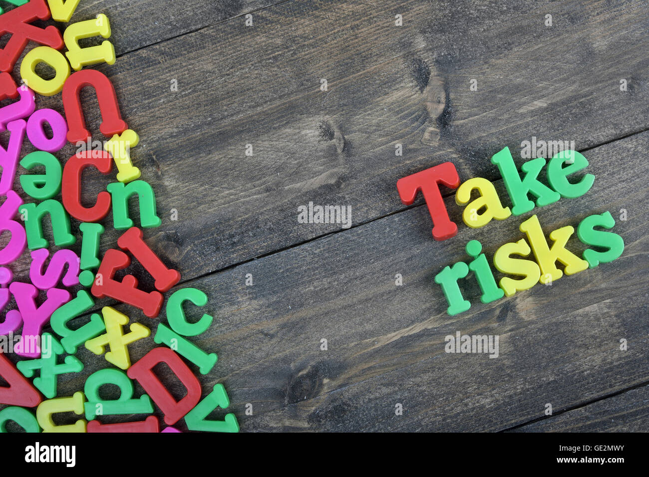 Take risks word on wooden table Stock Photo - Alamy