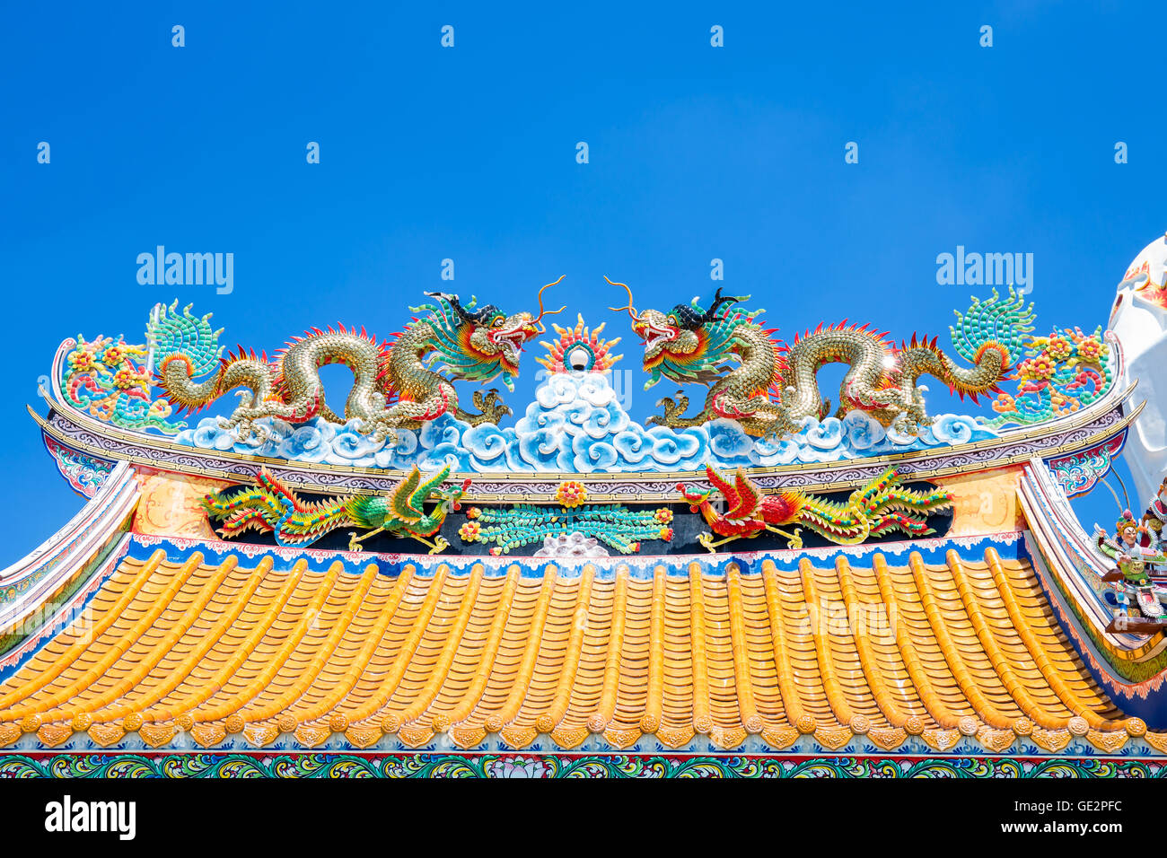 colorful twin dragons sculpture on public chinese temple roof with blue ...