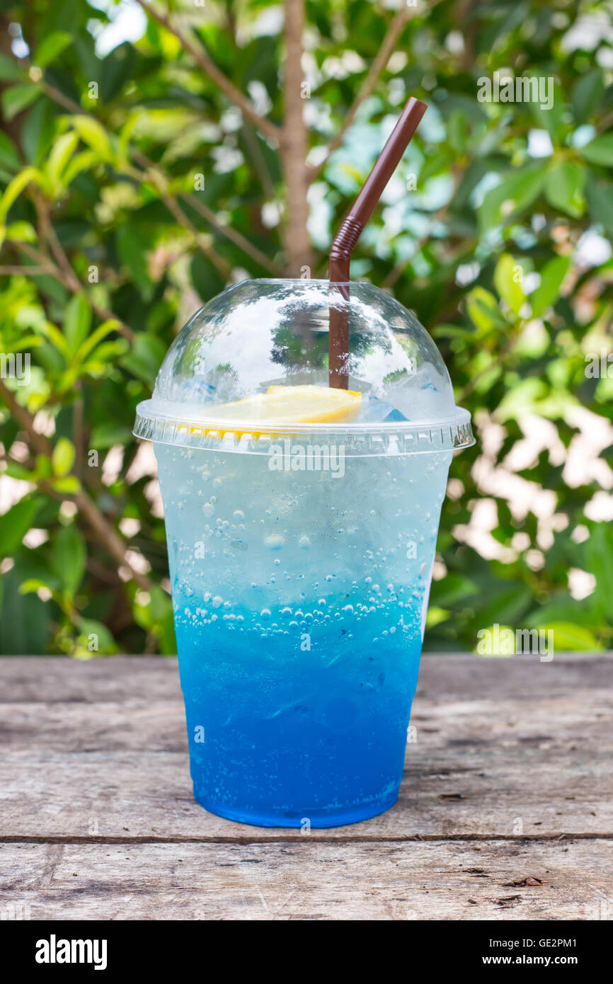 blue lemon soda on wood table with green leaves background, be fresh in ...