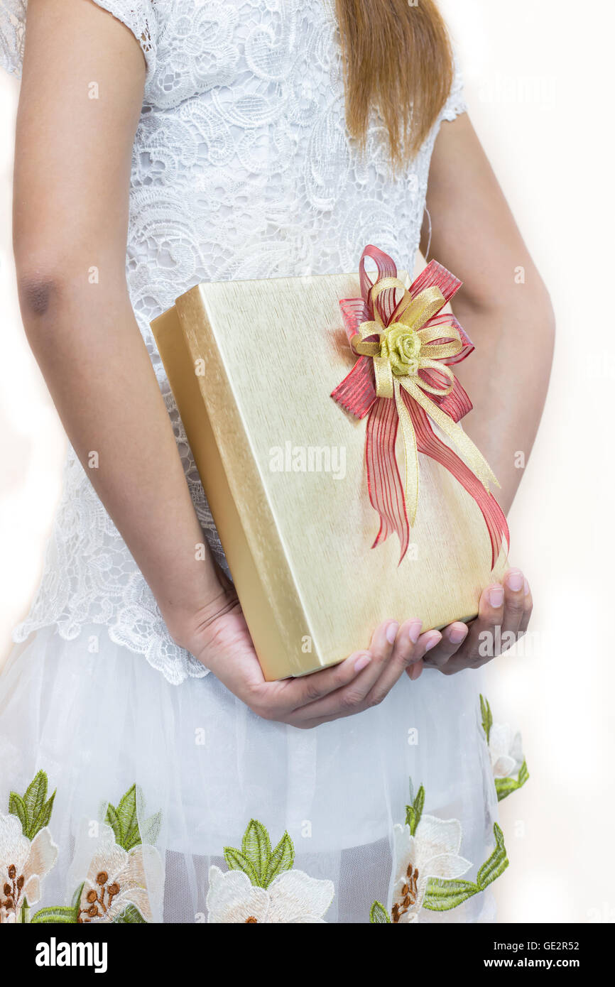 Women in white hiding a gift behind her back Stock Photo - Alamy
