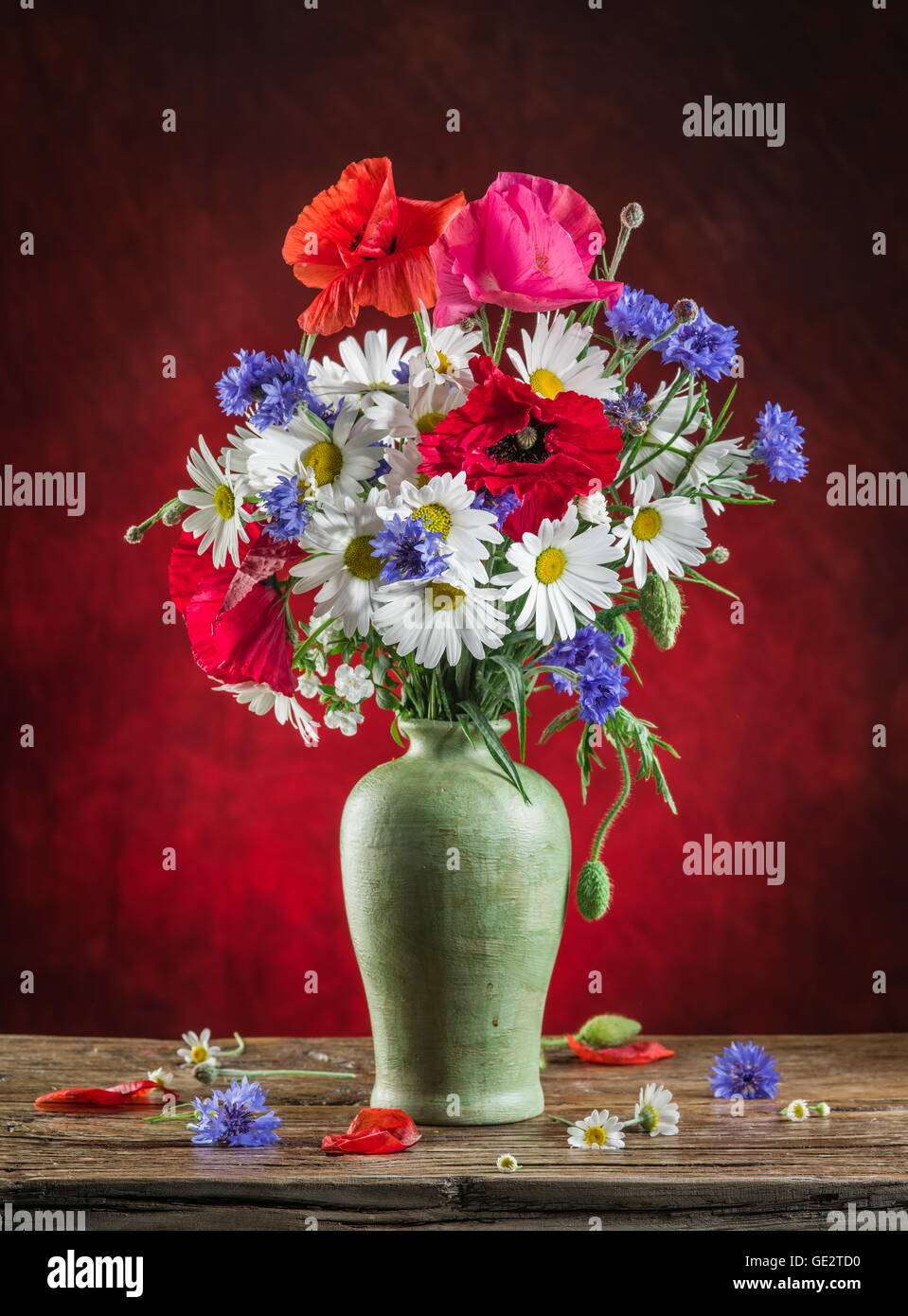 Bouquet of field flowers in the vase on the wooden table Stock Photo ...