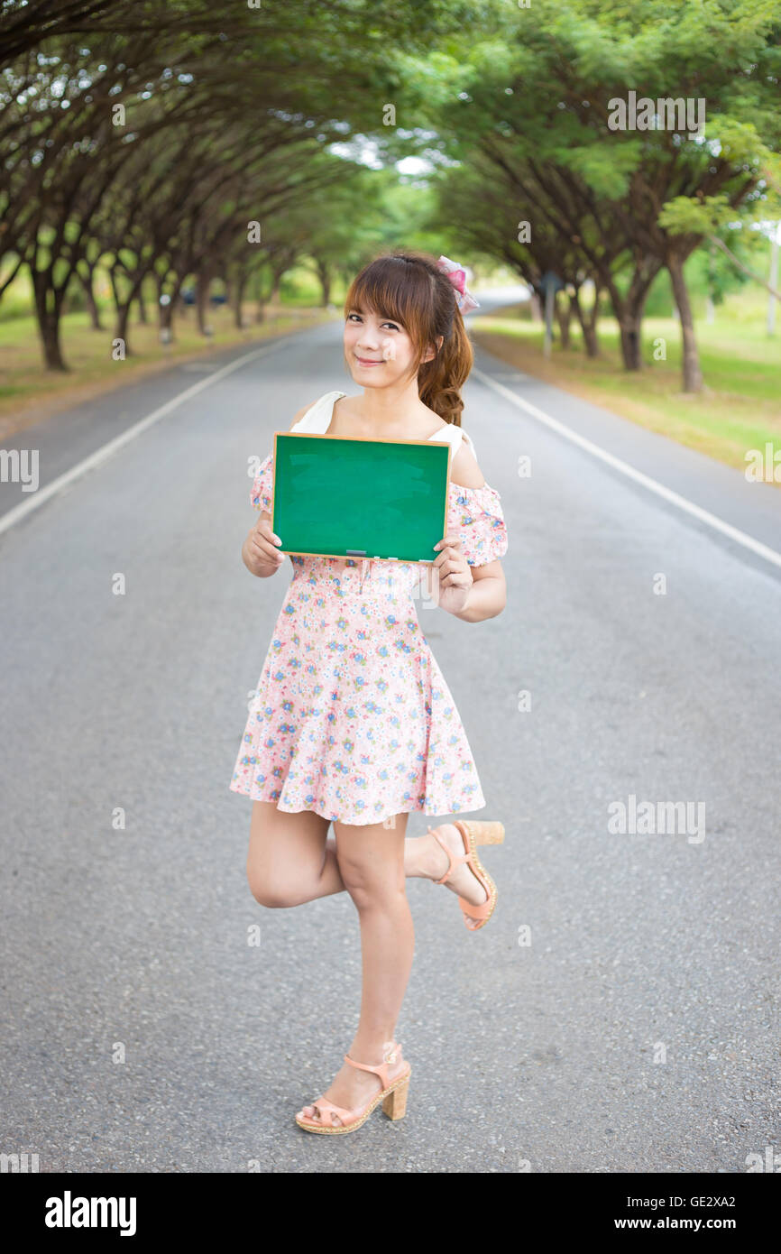 Cute woman hand holding green blank board sign on road with tree ...