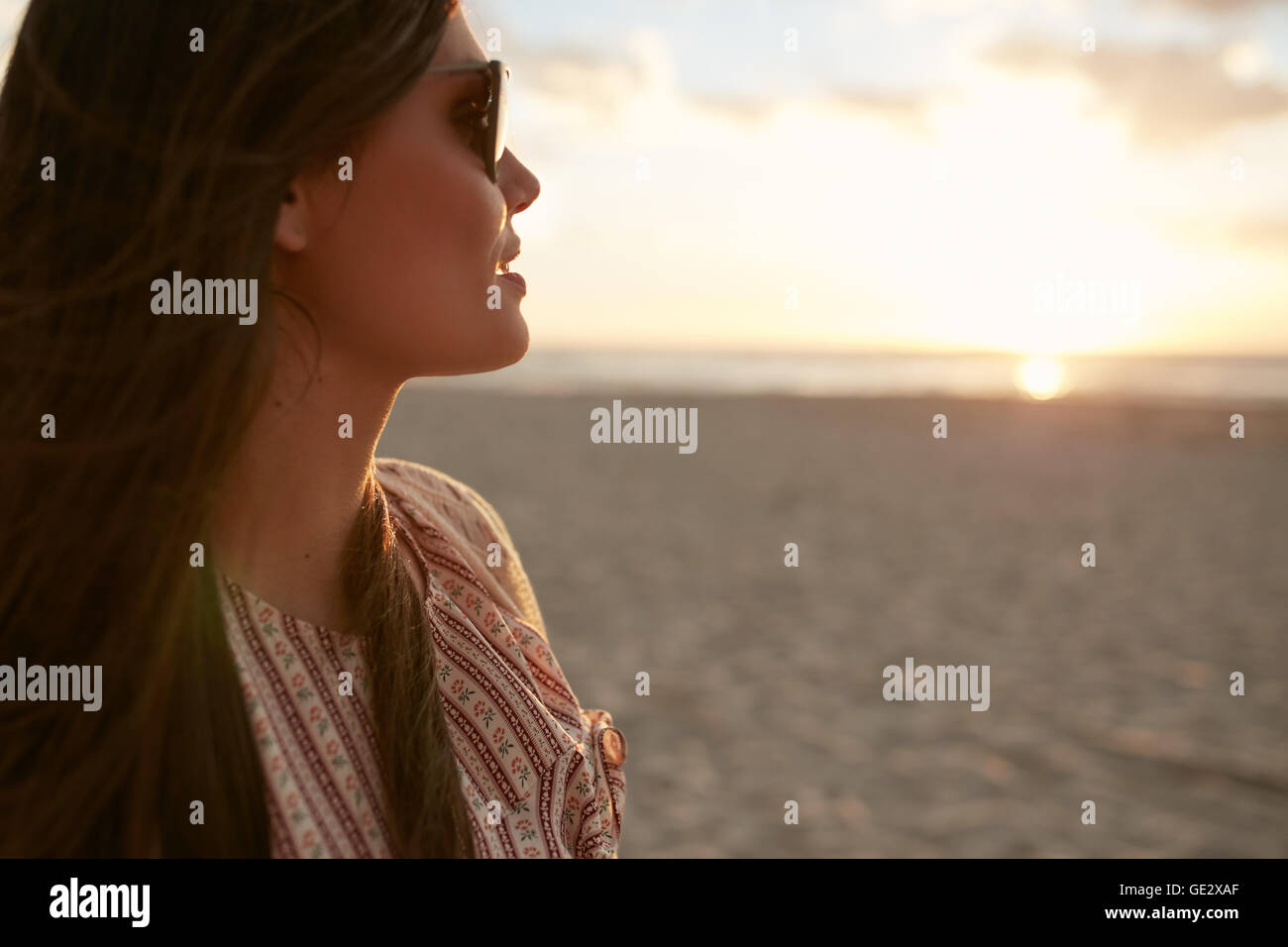 Close up shot of attractive young female with sunglasses looking at ...