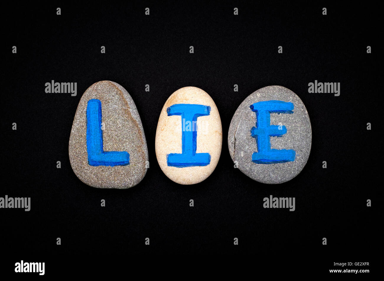 Word Lie spell out from stones with blue letters on black background ...