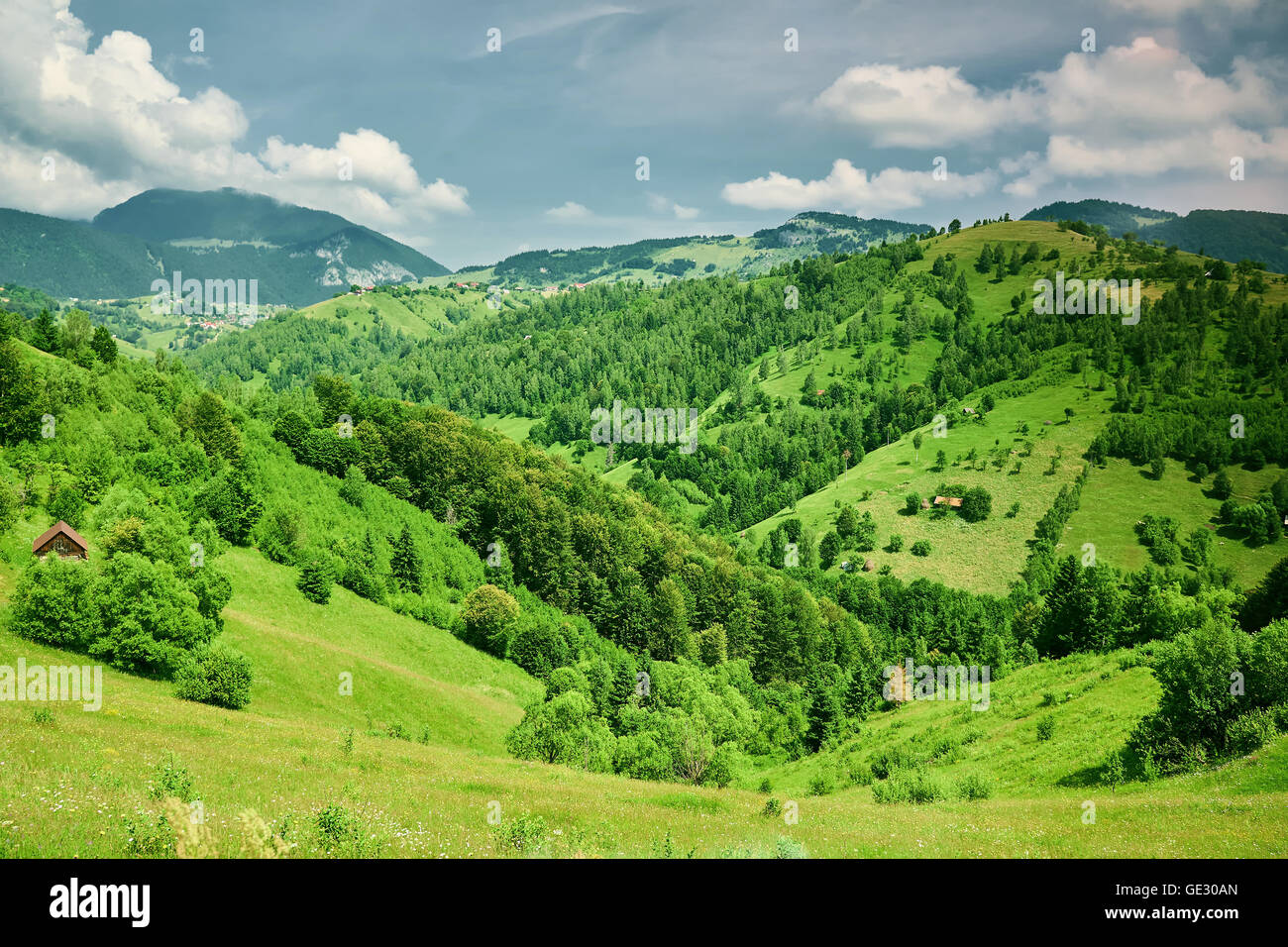 Cinematic scenery in nature, green fields and mountains, blue sky with ...