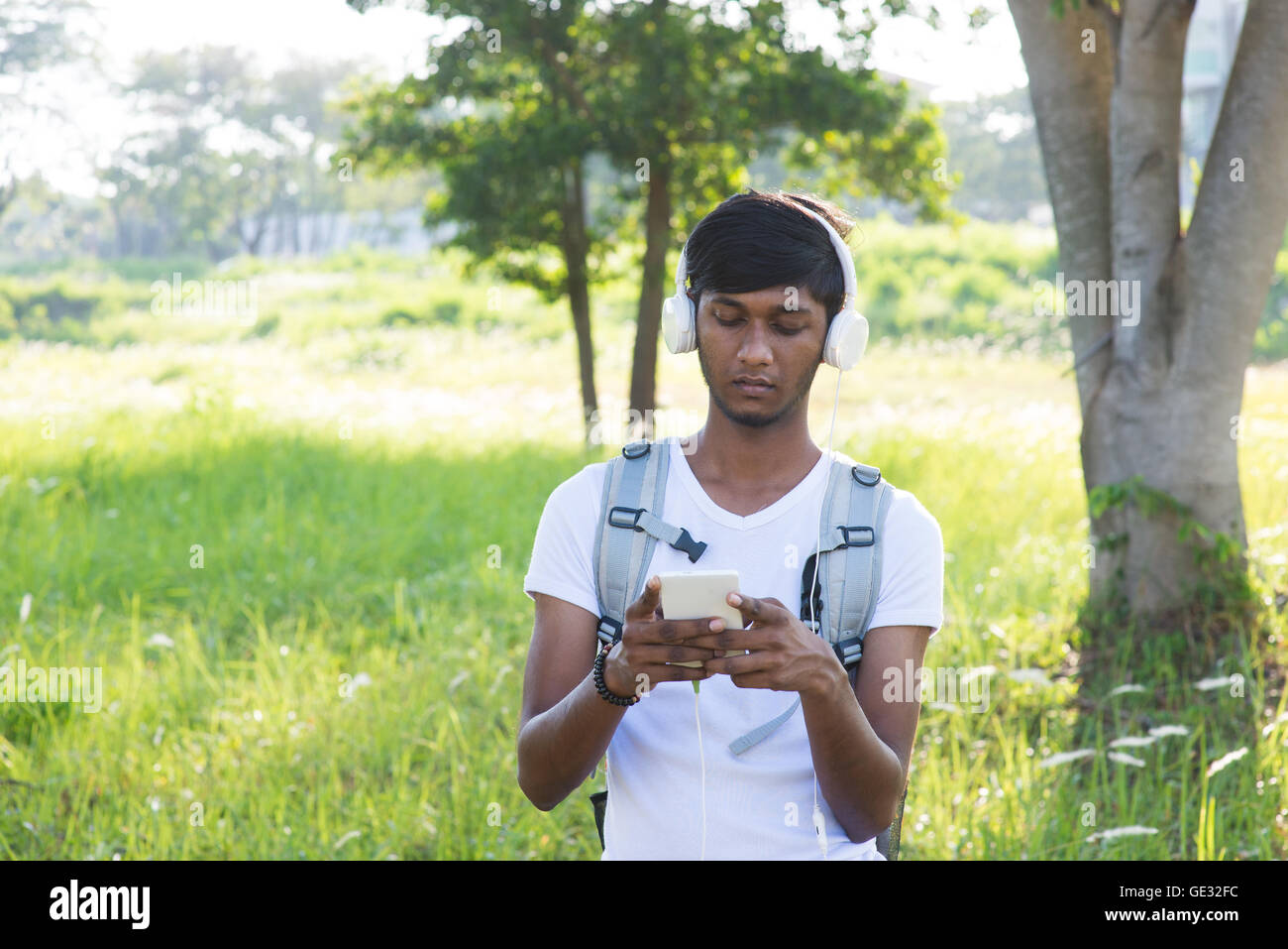 indian male college student listening to music outdoor Stock Photo - Alamy