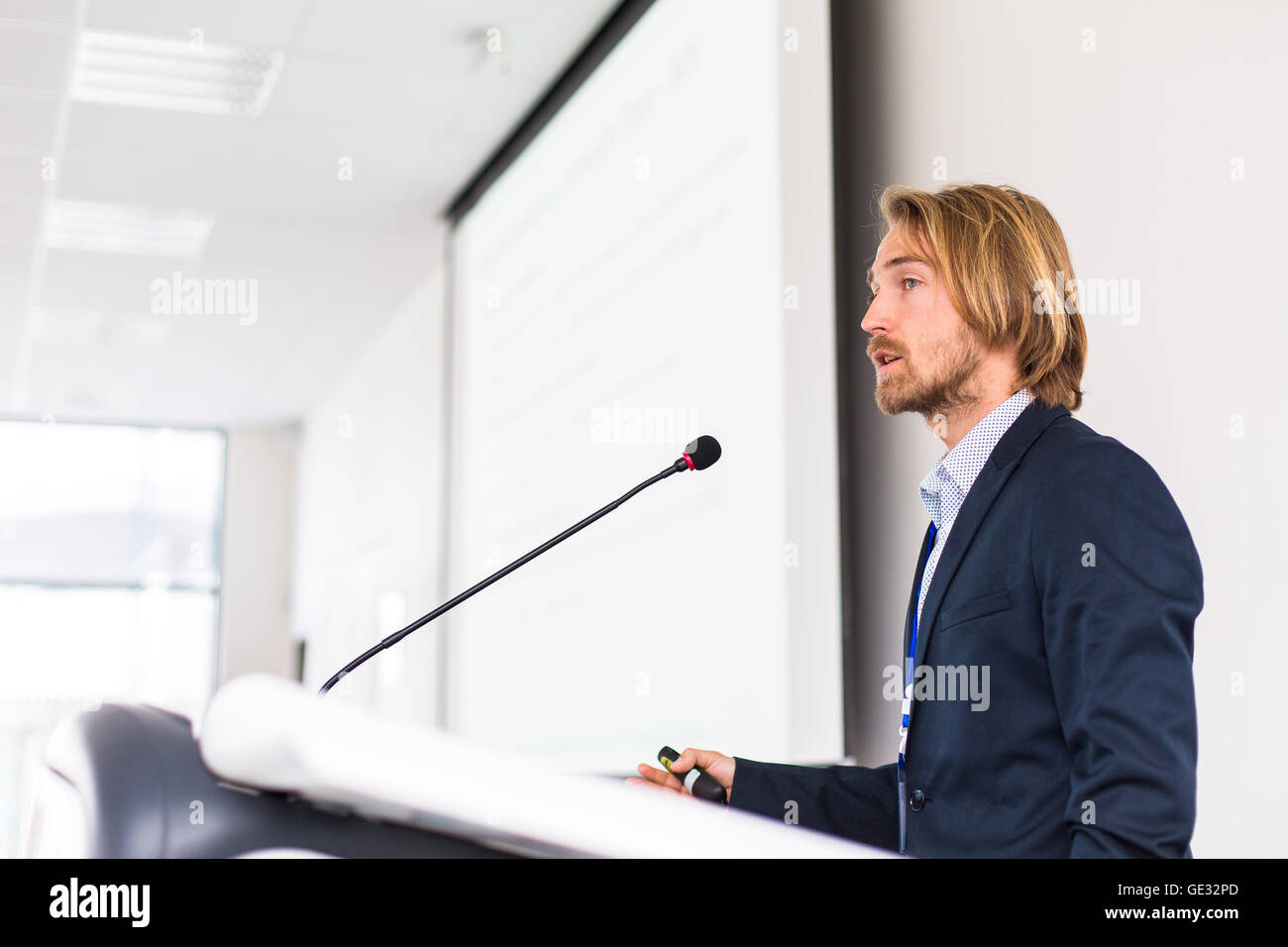Handsome young man giving a speech at a conference Stock Photo - Alamy