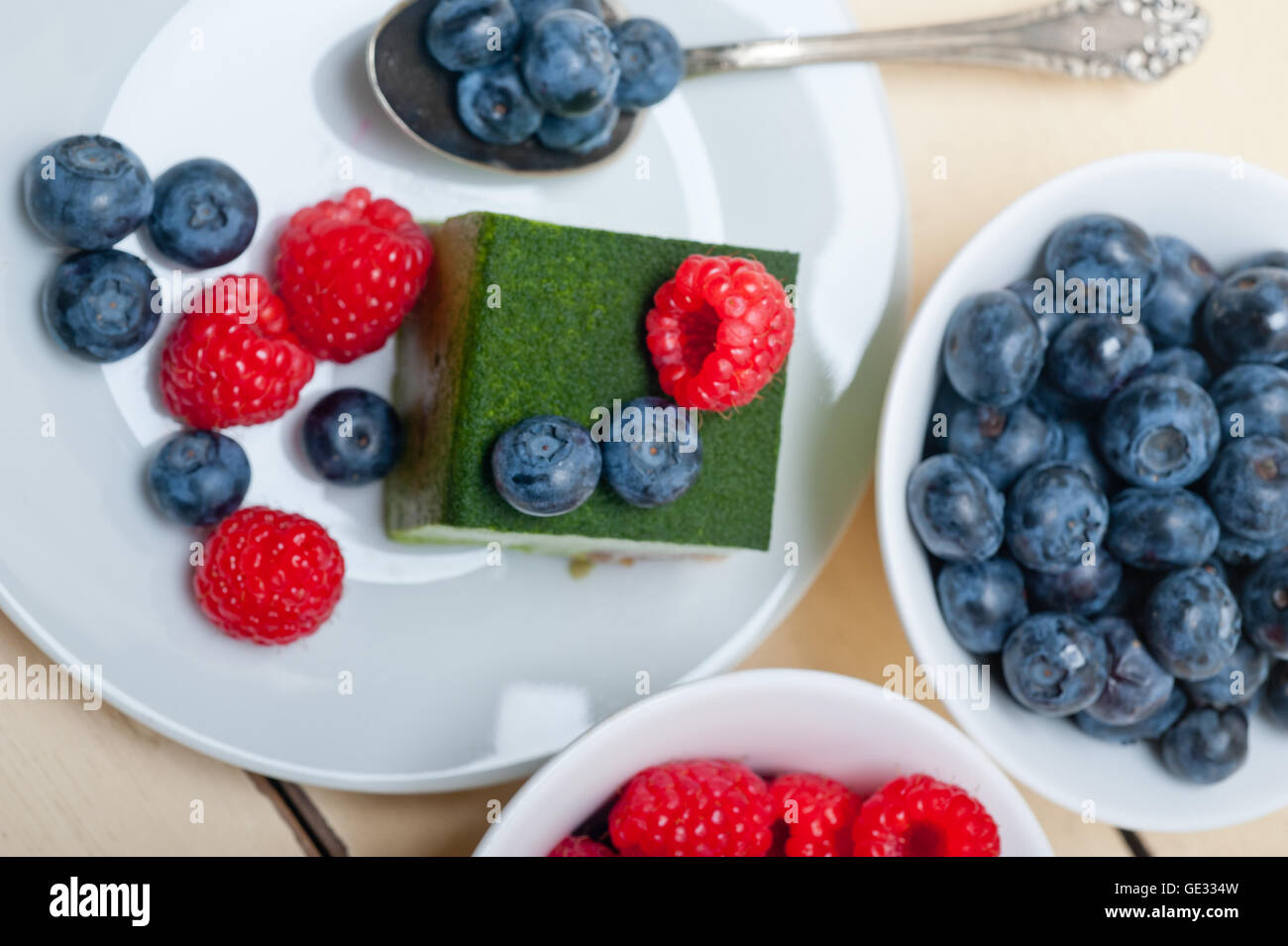 green tea matcha mousse cake with raspberries and blueberries on top ...