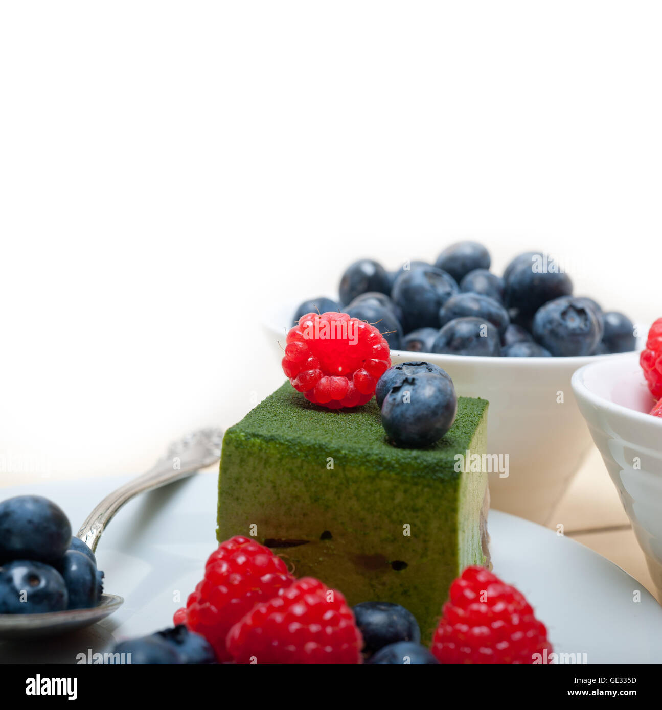 green tea matcha mousse cake with raspberries and blueberries on top ...