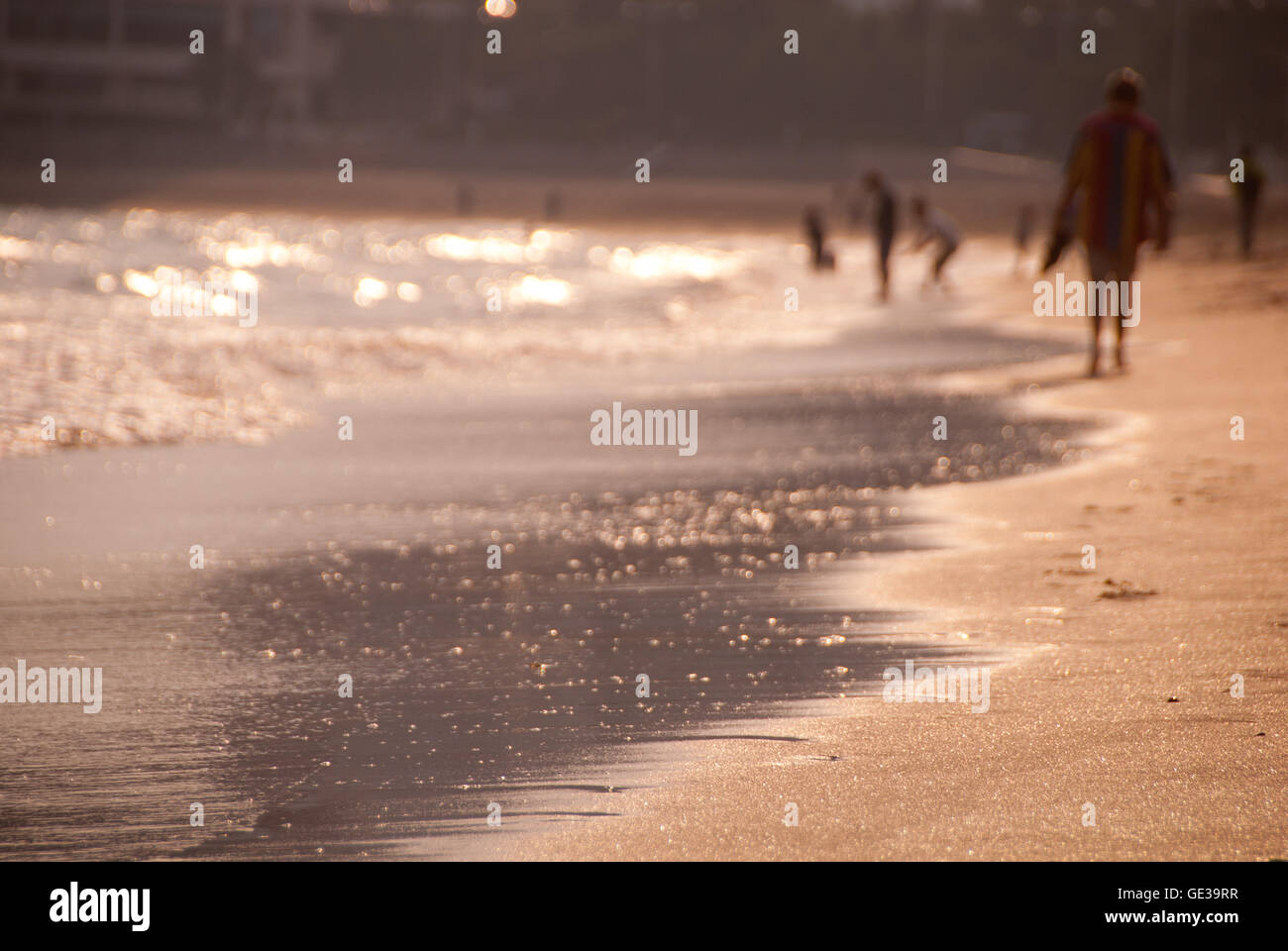 People on the beach at sunset Stock Photo - Alamy