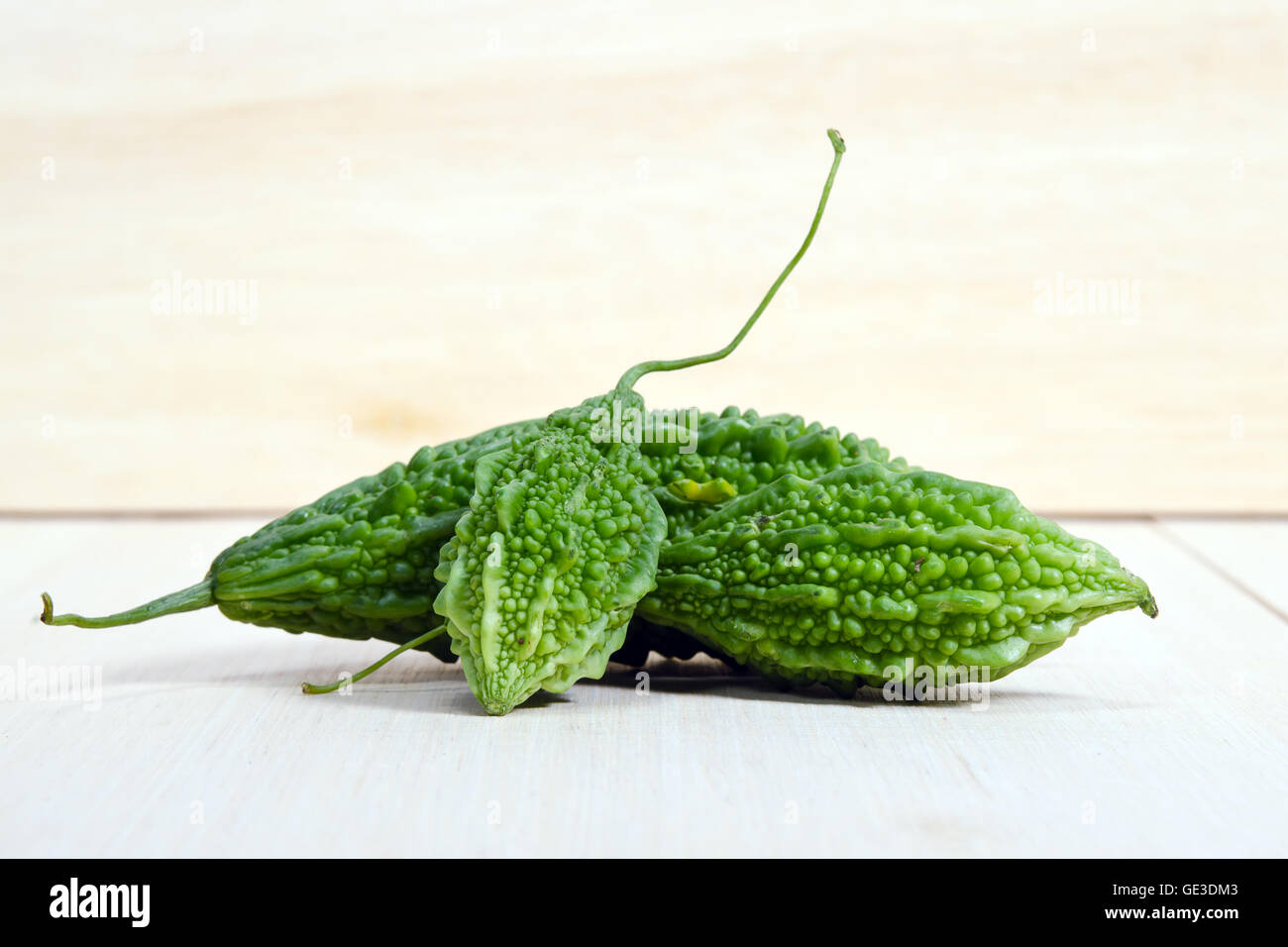 Closeup view of bitter gourd over wooden board background Stock Photo ...