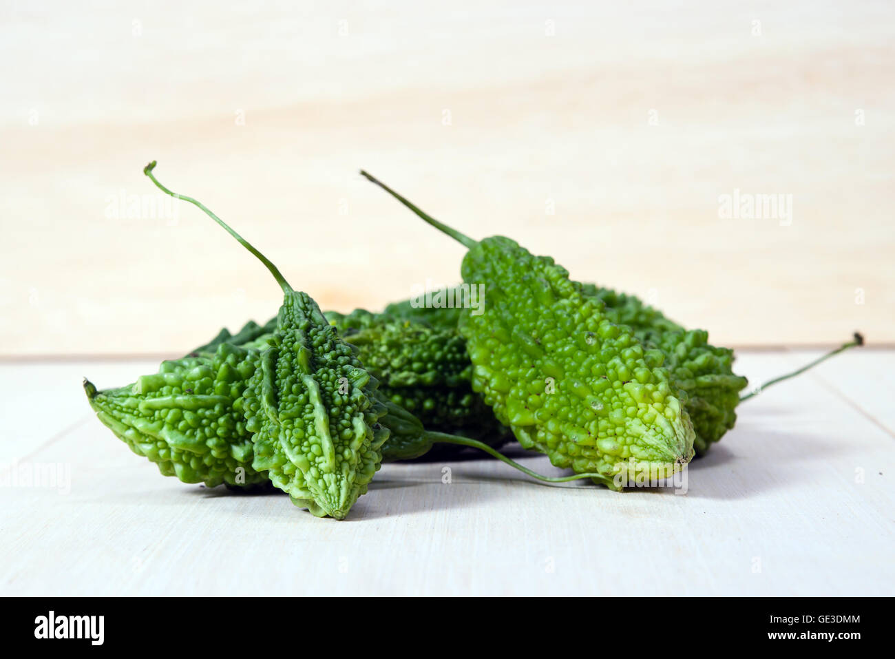 Closeup view of bitter gourd over wooden board background Stock Photo ...