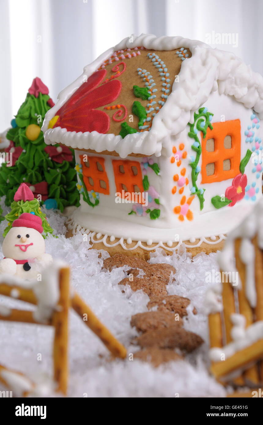 Gingerbread house painted in ethnic style among the trees and snow ...