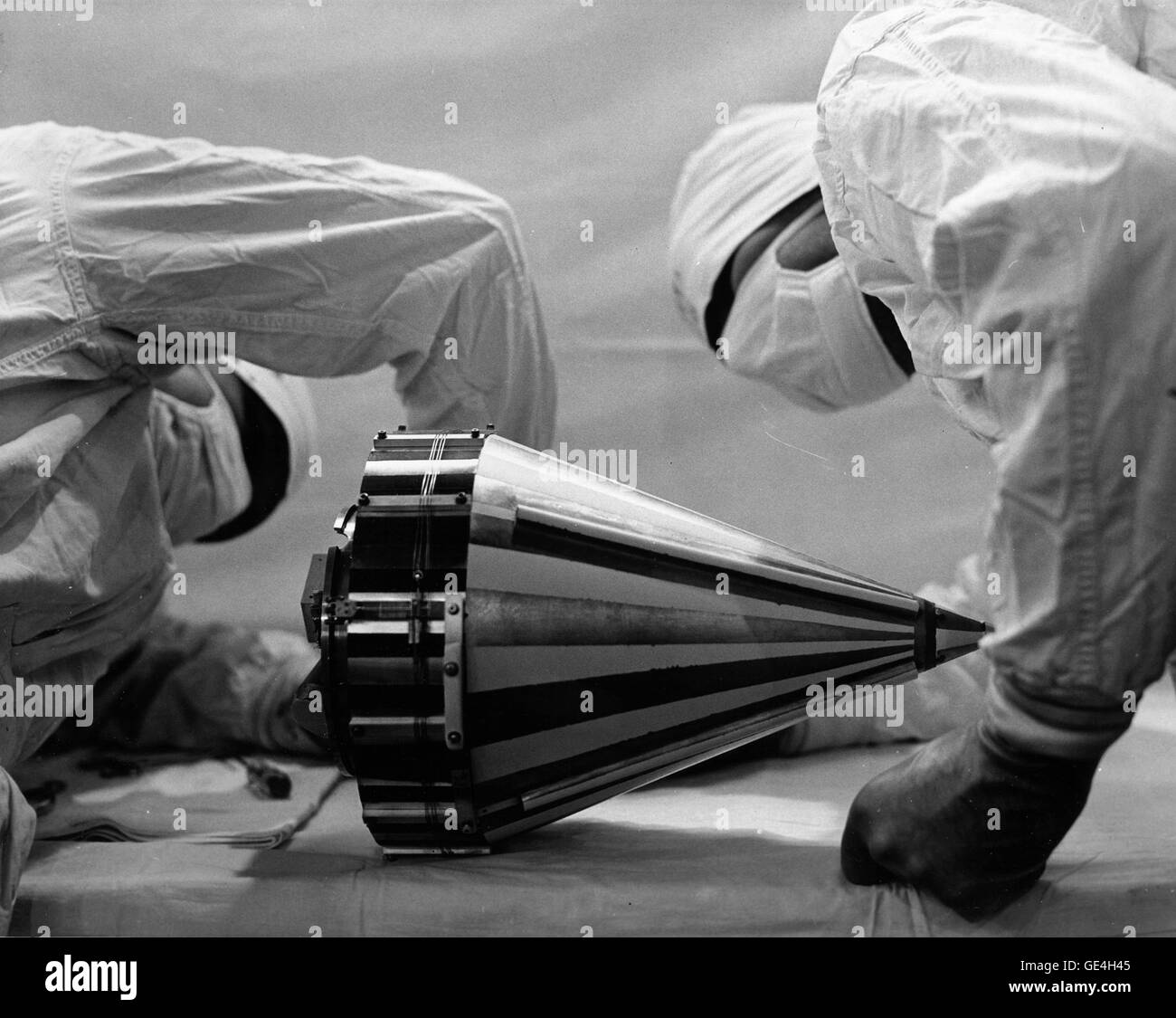 Technicians in cleanroom attire inspect the Pioneer III probe at NASA's ...