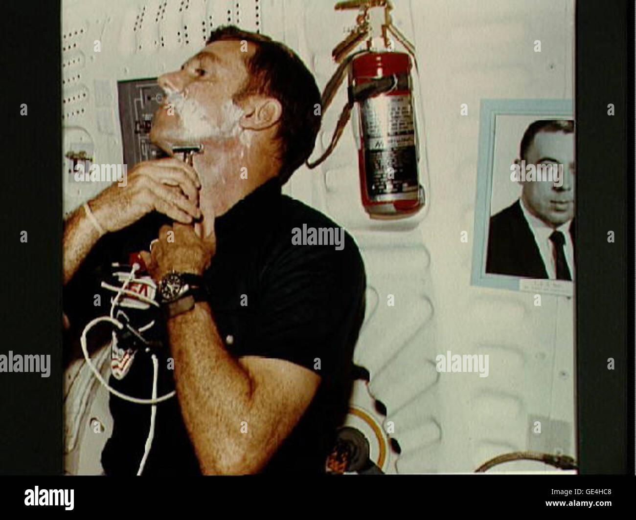 This photograph shows an astronaut performing a shaving routine in ...