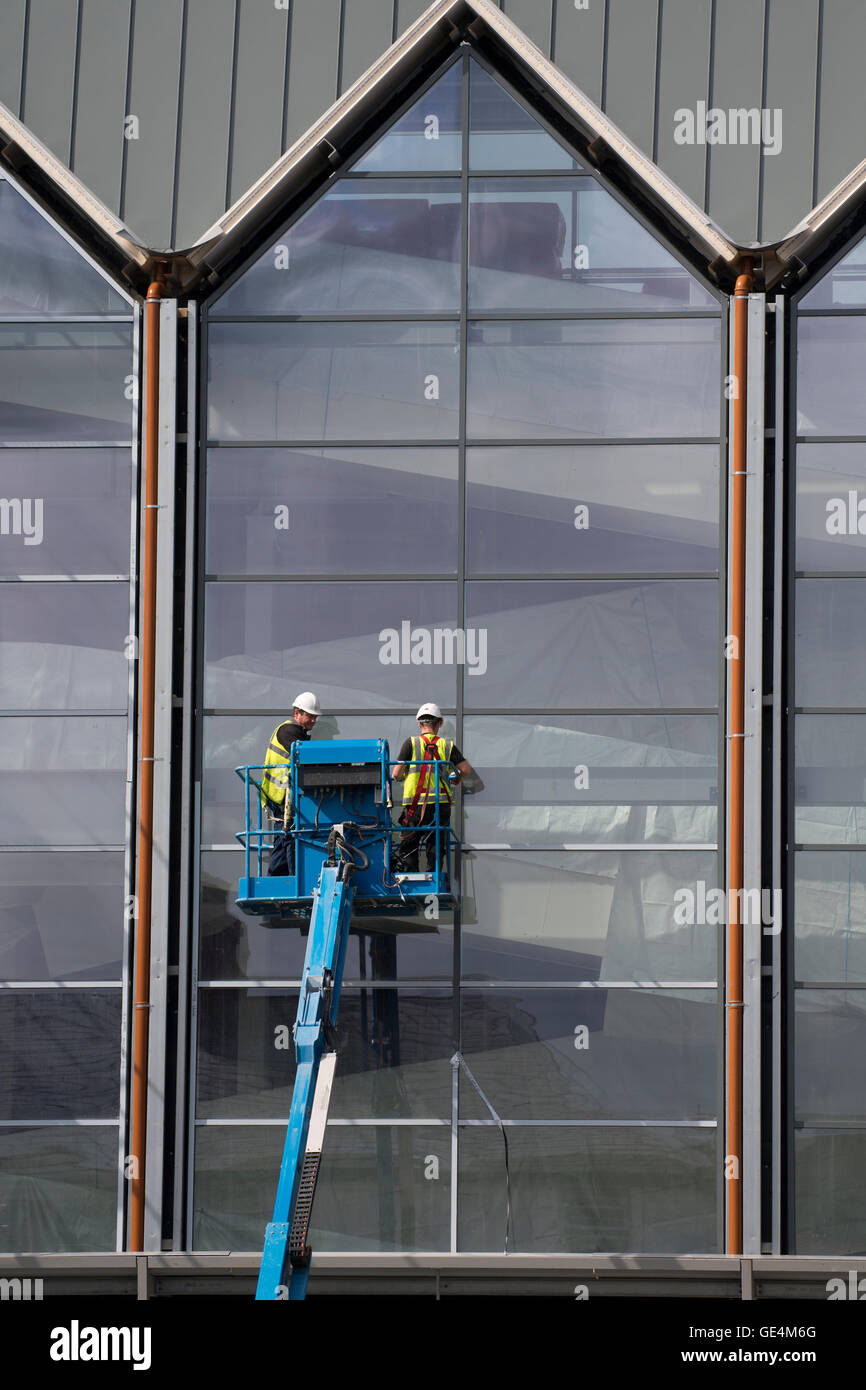 Construction work in the UK: two workers in an elevated 'cherry picker ...