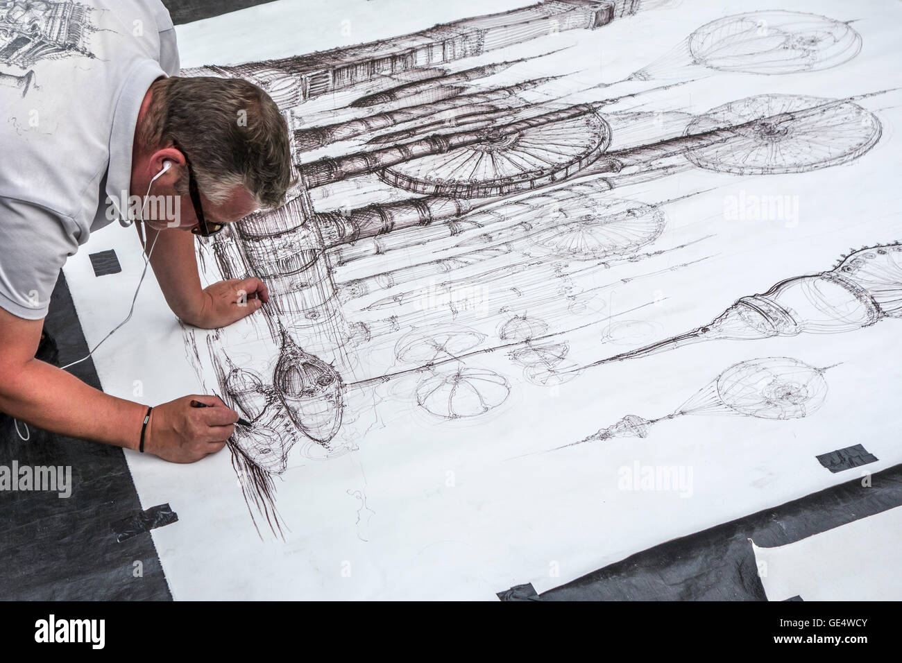 Street artist making fine detailed black and white drawing of imaginary ...