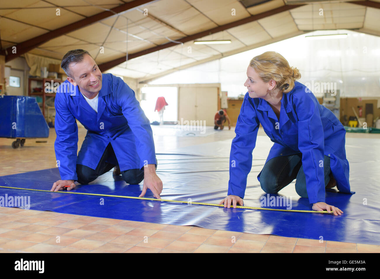 rolling out tarpaulin Stock Photo - Alamy