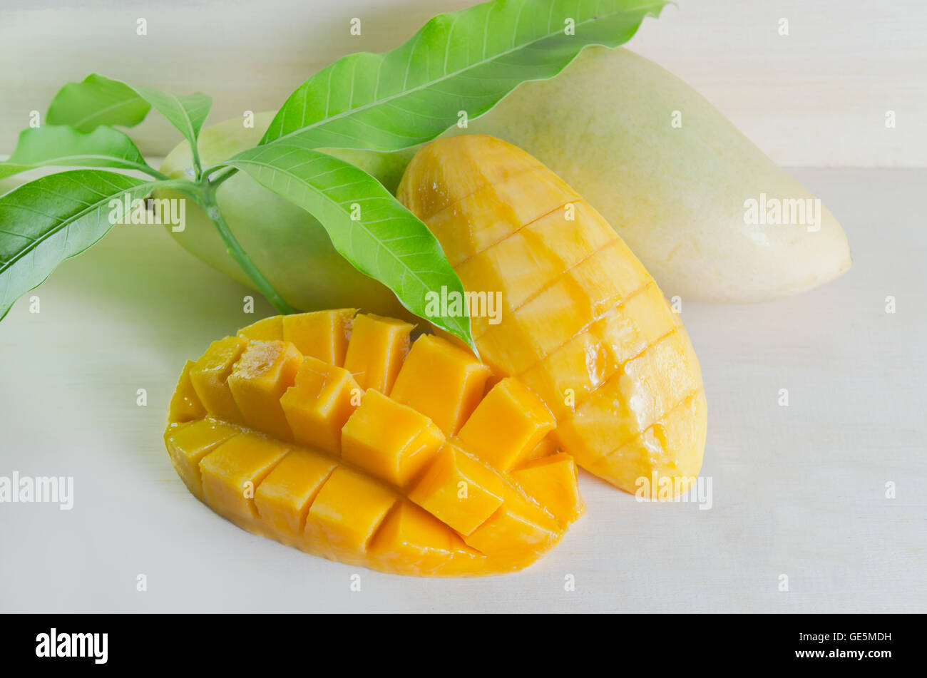 Mango ripe with nicely cut pieces and leaf on wooden board (Other names ...