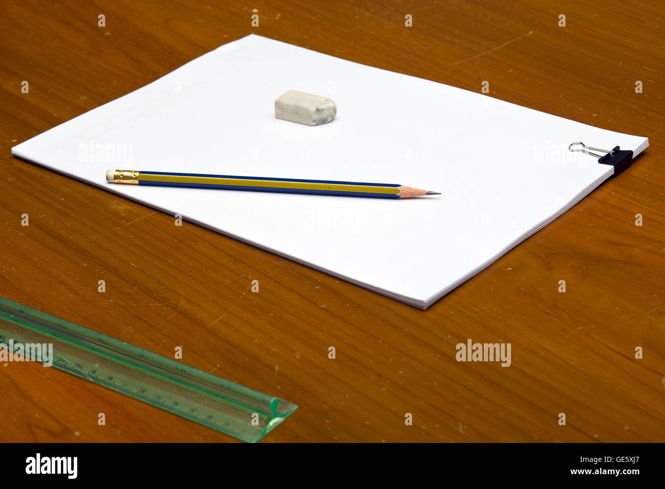 View of pencil, erasers and pile of papers Stock Photo - Alamy