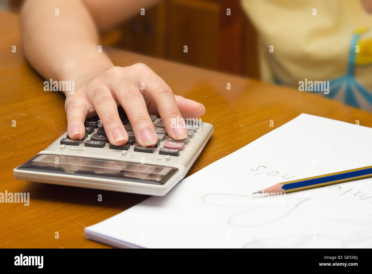 A woman notes and calculates number on the note card with calculator in ...