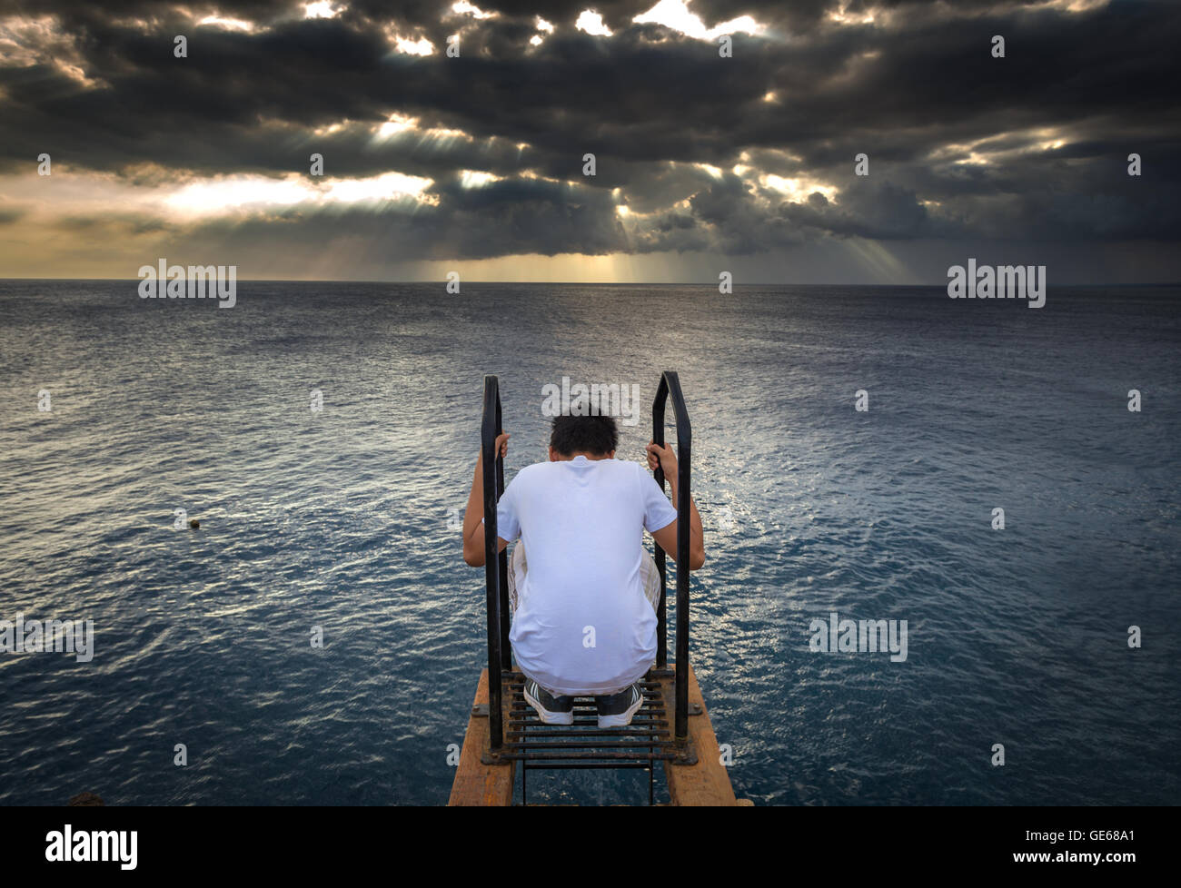 Depressed young boy on the cliff. Suicide concept Stock Photo - Alamy