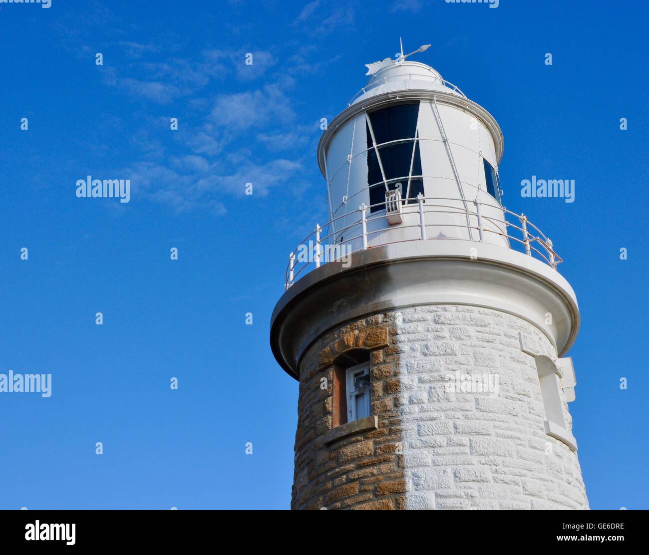 Half-painted limestone Woodman Point Lighthouse with a bright blue sky ...
