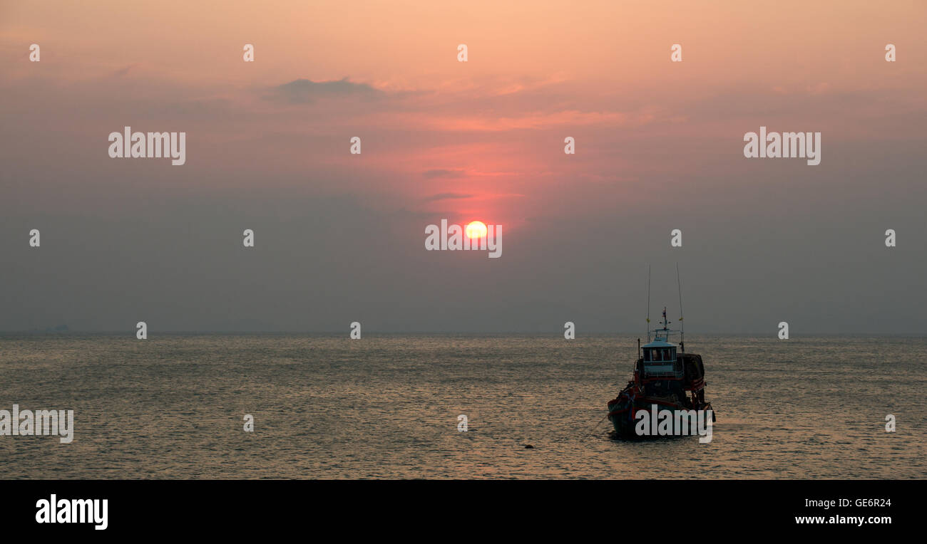 golden sunset over sea and sky with fishing boat Stock Photo - Alamy
