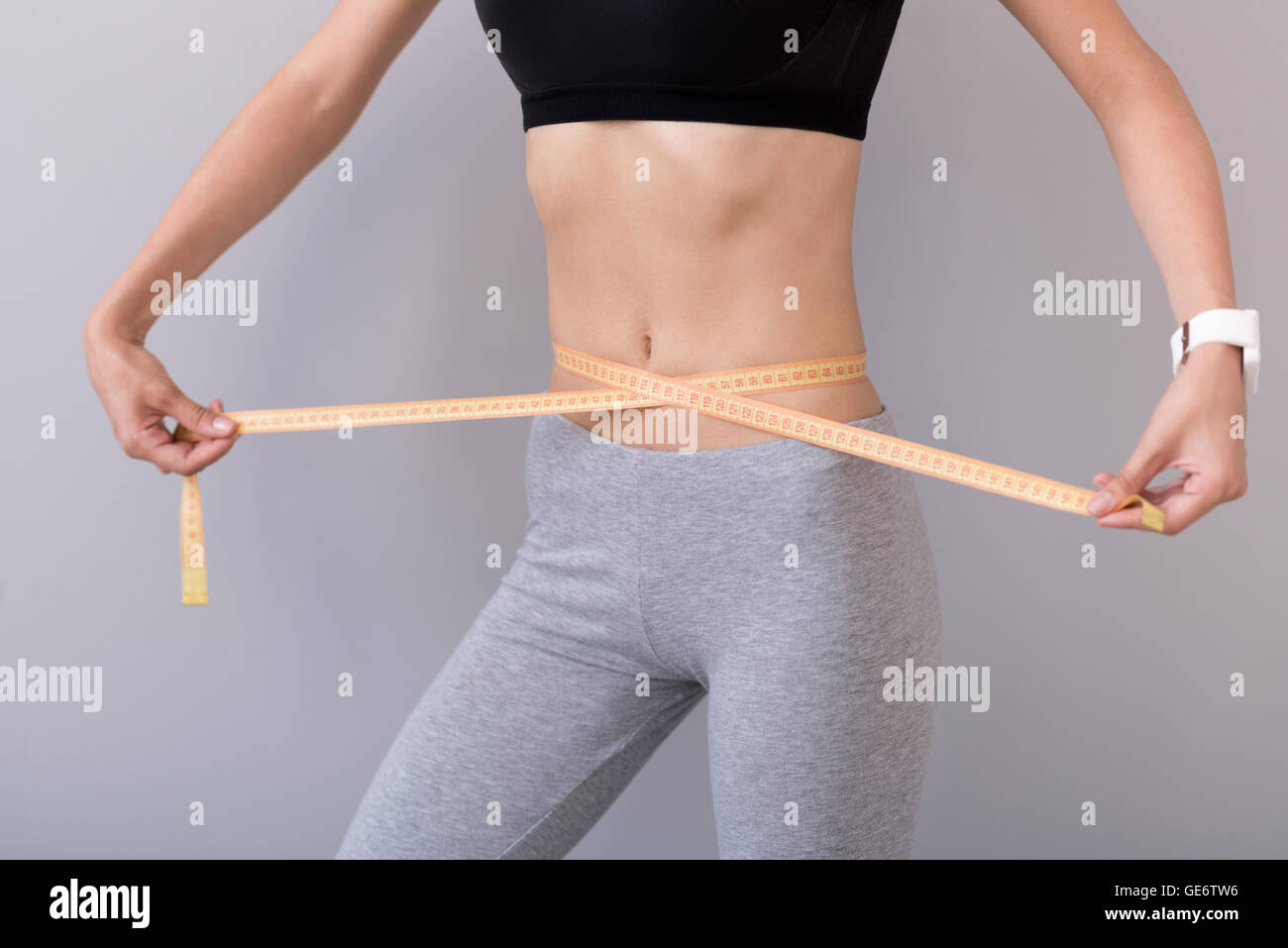 Slim woman using tape measure Stock Photo - Alamy