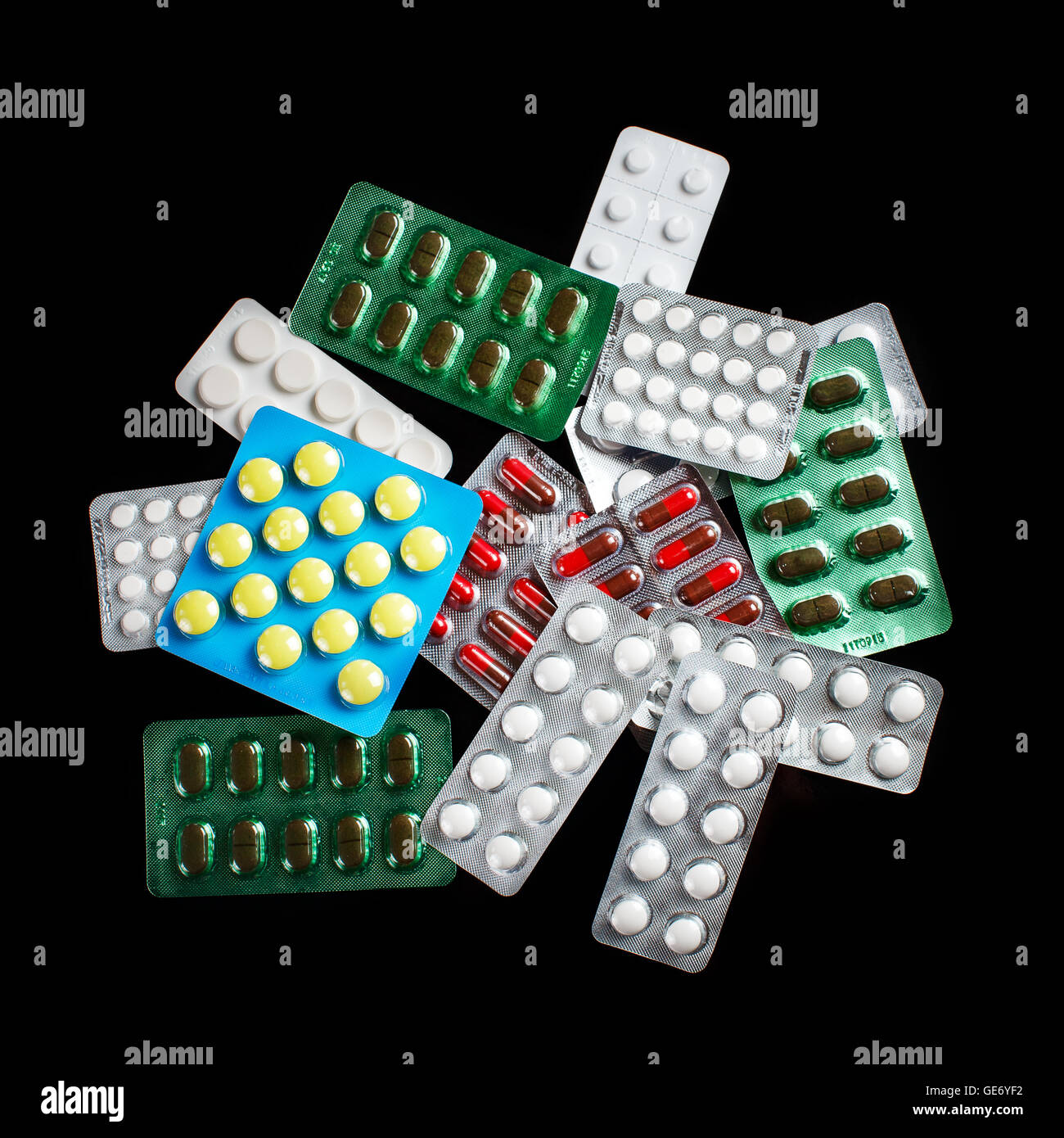Heap of different sorts of medication and pills in packs on black ...