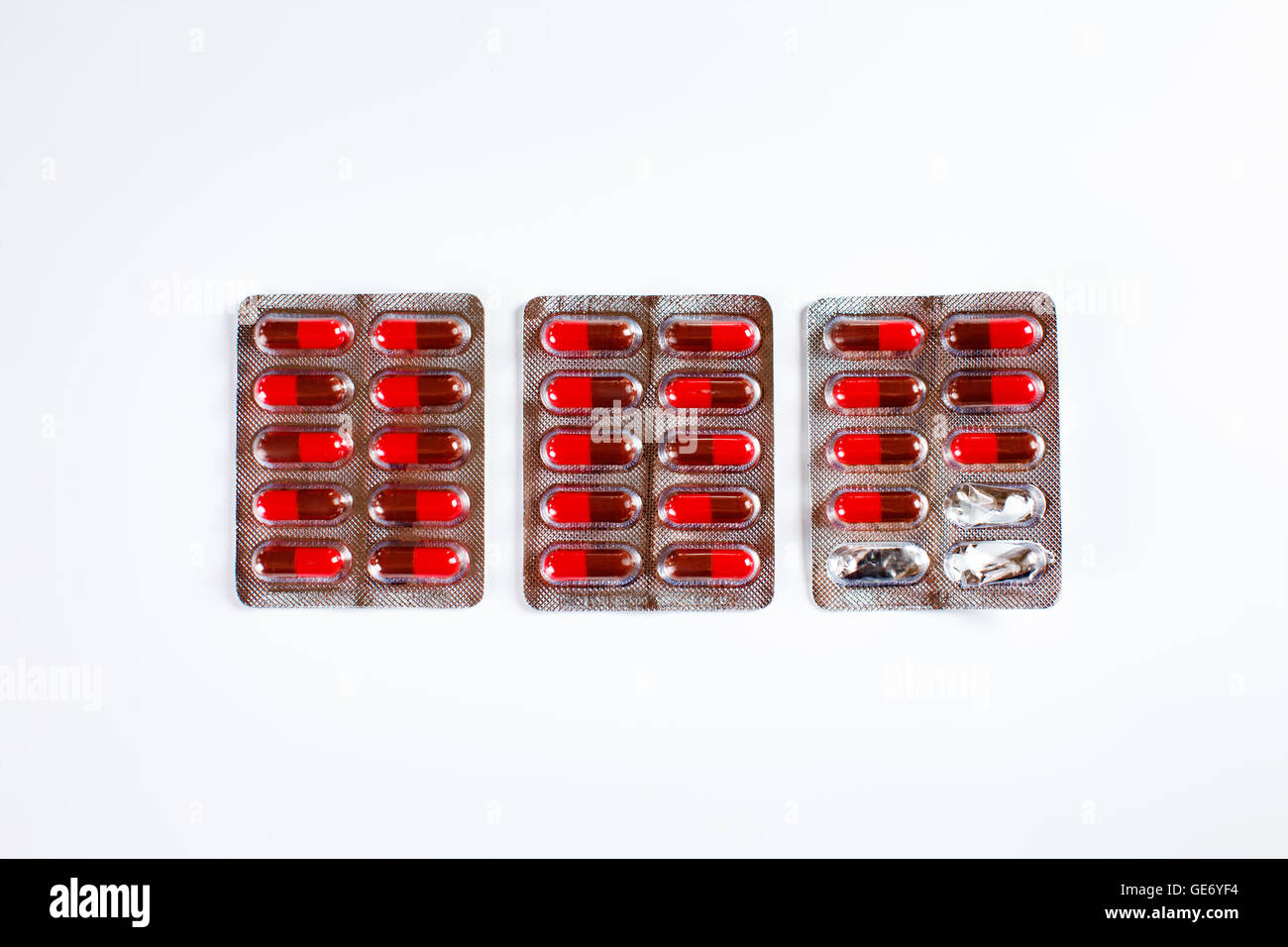 Row of blisters with red gelatin capsules, new and opened. View from ...