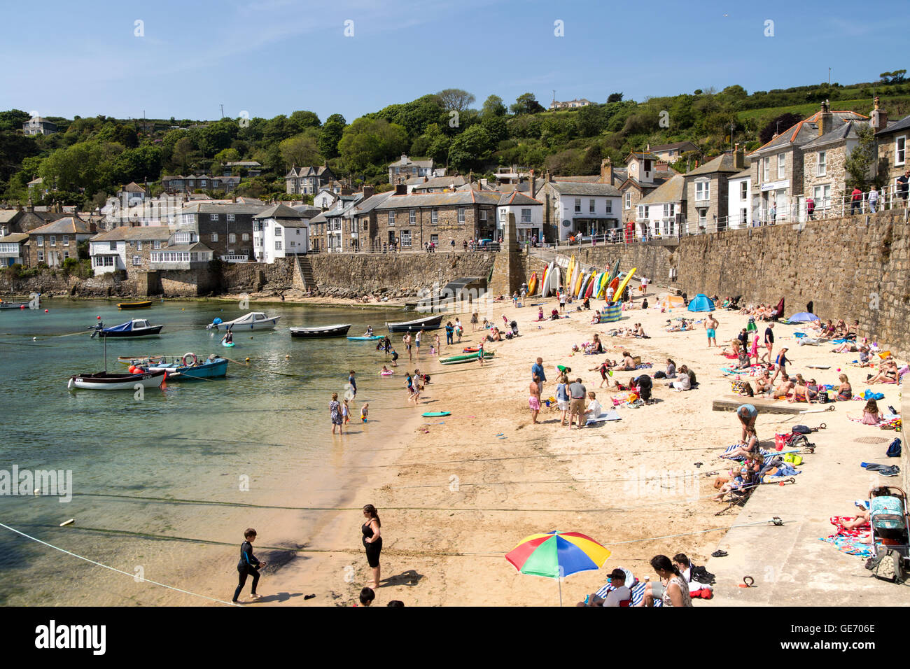 People on crowded beach in Mousehole village, Cornwall, England, UK ...