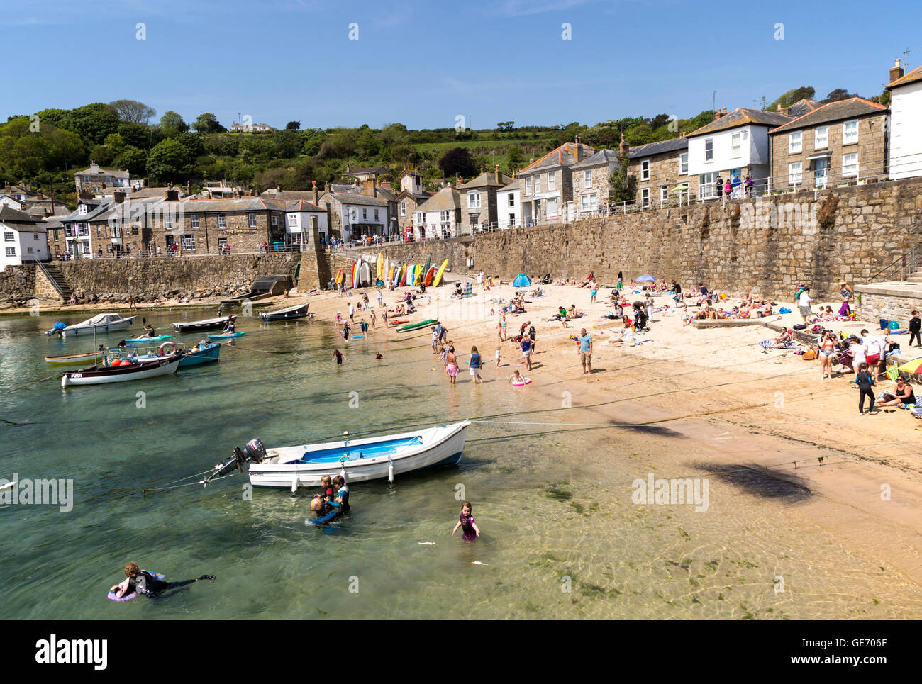 People on crowded beach in Mousehole village, Cornwall, England, UK ...