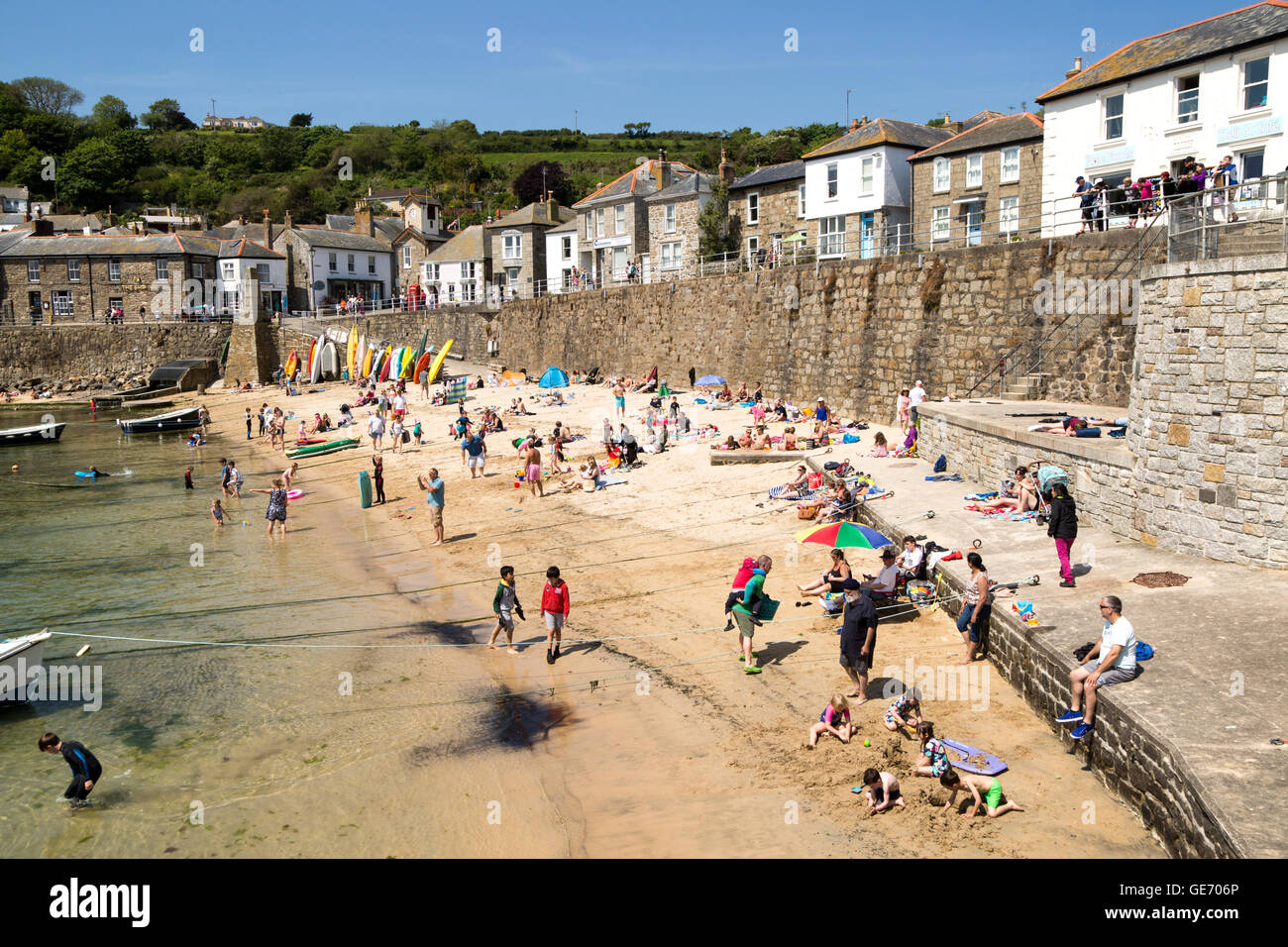 People on crowded beach in Mousehole village, Cornwall, England, UK ...