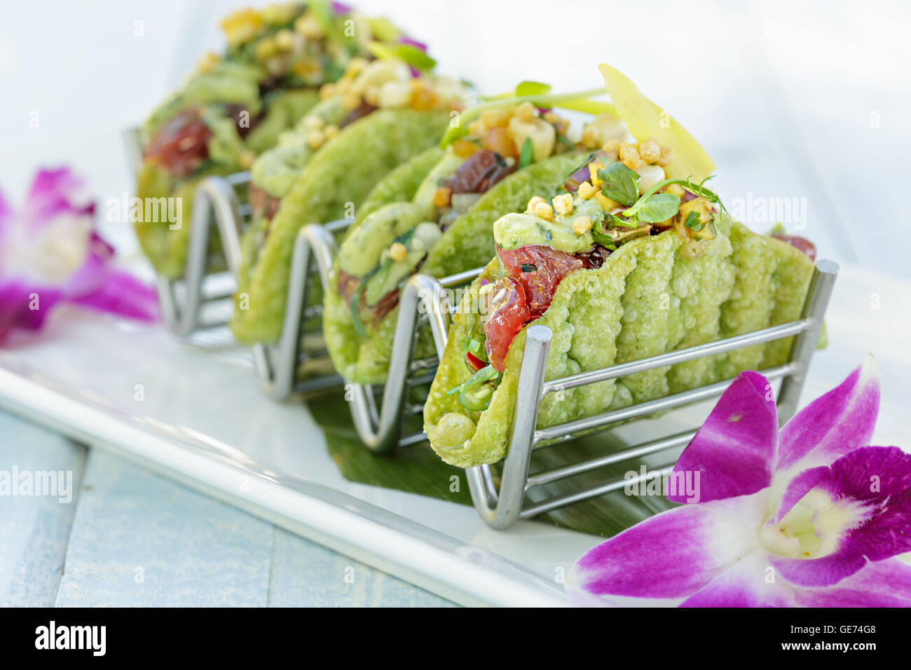 Ahi poke tacos with avocado mousse, island salsa, bubu arare in a mini ...