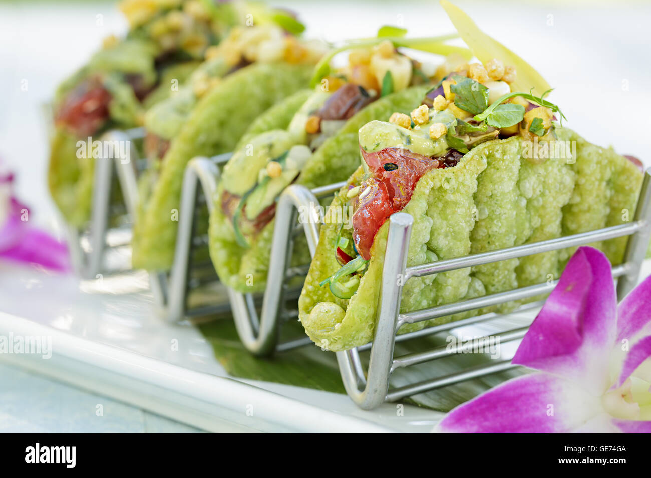 Ahi poke tacos with avocado mousse, island salsa, bubu arare in a mini ...