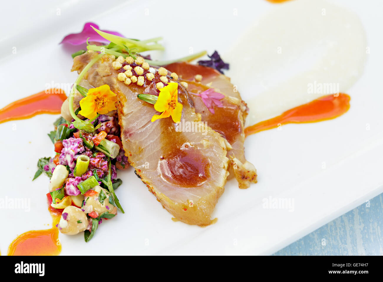 Charred Hamachi seasoned with togarashi and garnished with edible ...