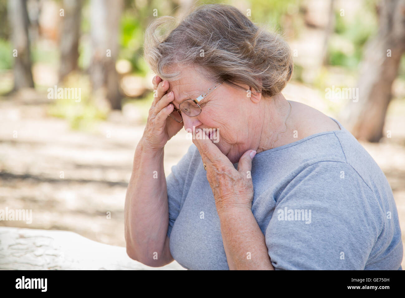 Upset Senior Woman Sitting Alone Outside Stock Photo - Alamy