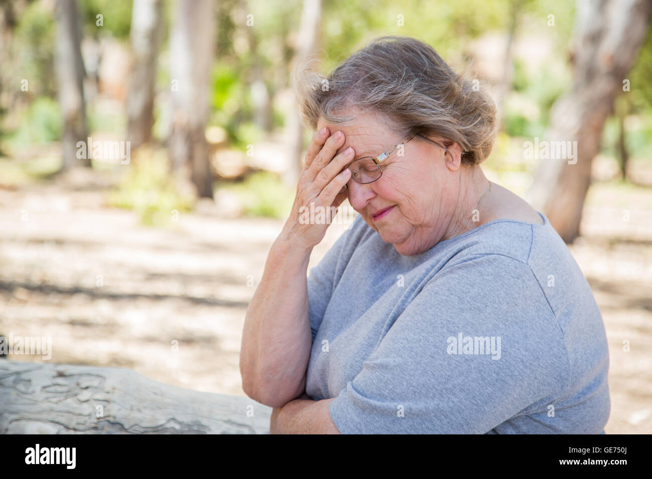 Upset Senior Woman Sitting Alone Outside Stock Photo - Alamy
