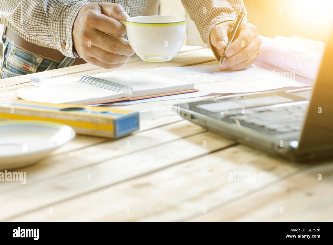 Young man working around construction project with his laptop with ...