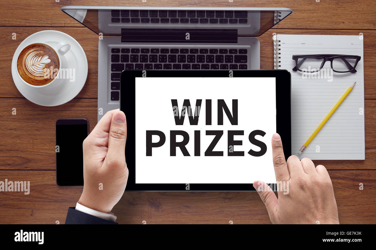 WIN PRIZES, on the tablet pc screen held by businessman hands - online ...