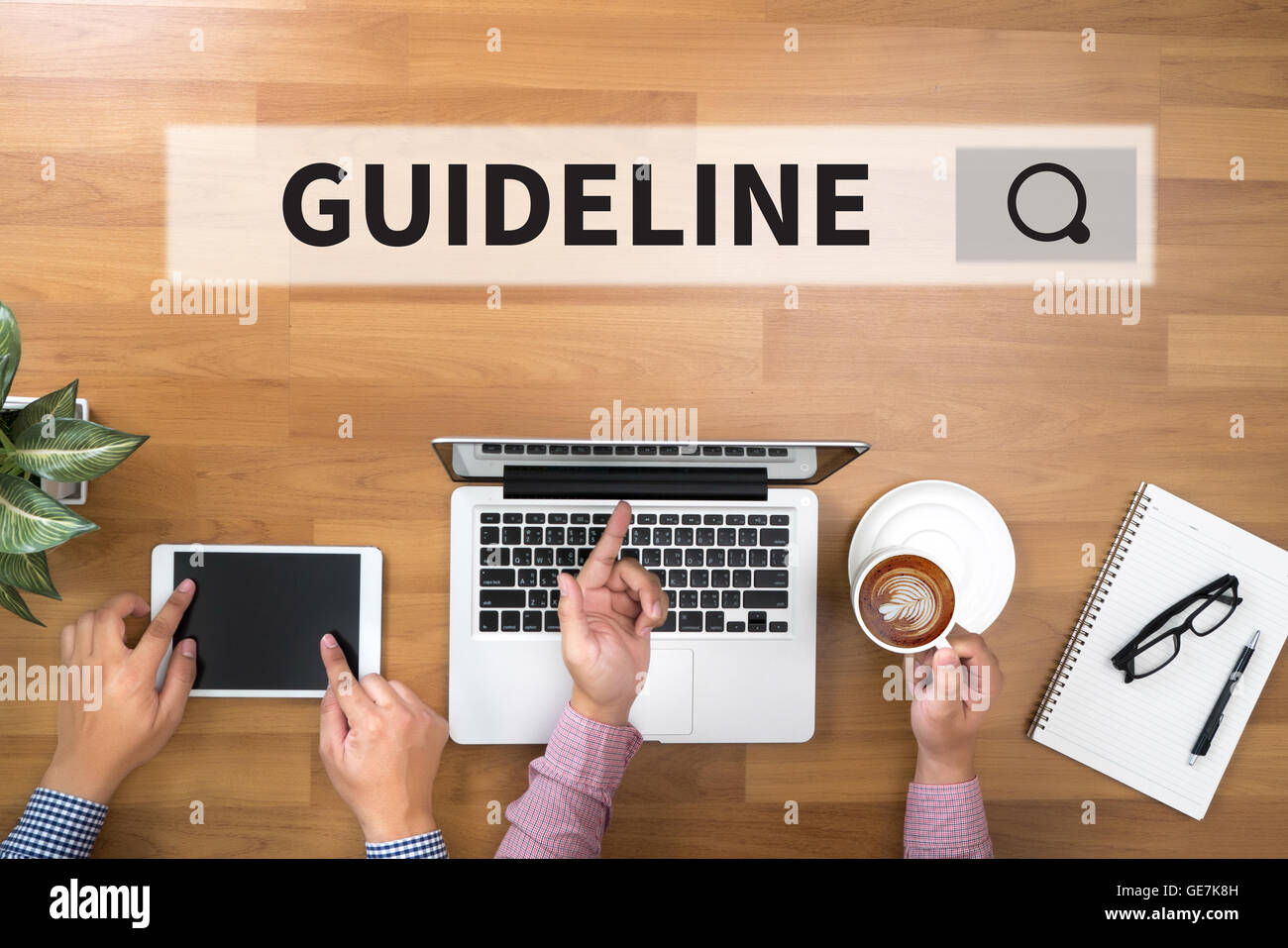 GUIDELINE Two Businessman working at office desk and using a digital ...