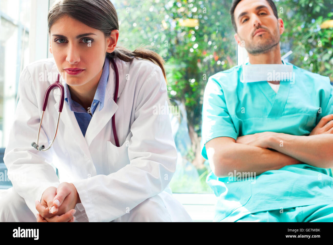 Portrait of serious female doctor with colleague in hospital. Young ...
